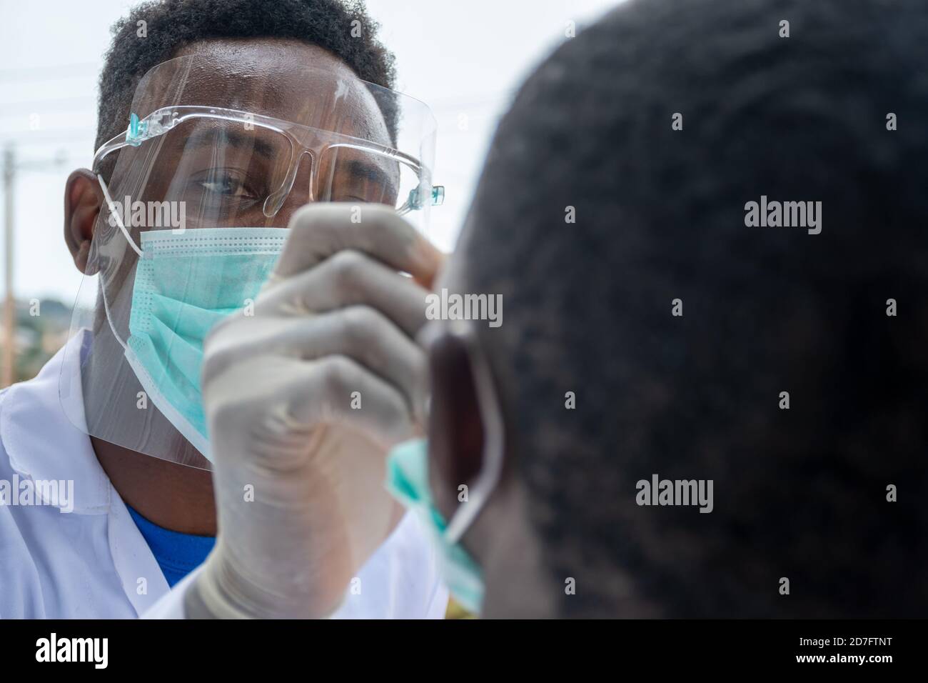 african lab scientist taking nasal sample from a man Stock Photo - Alamy