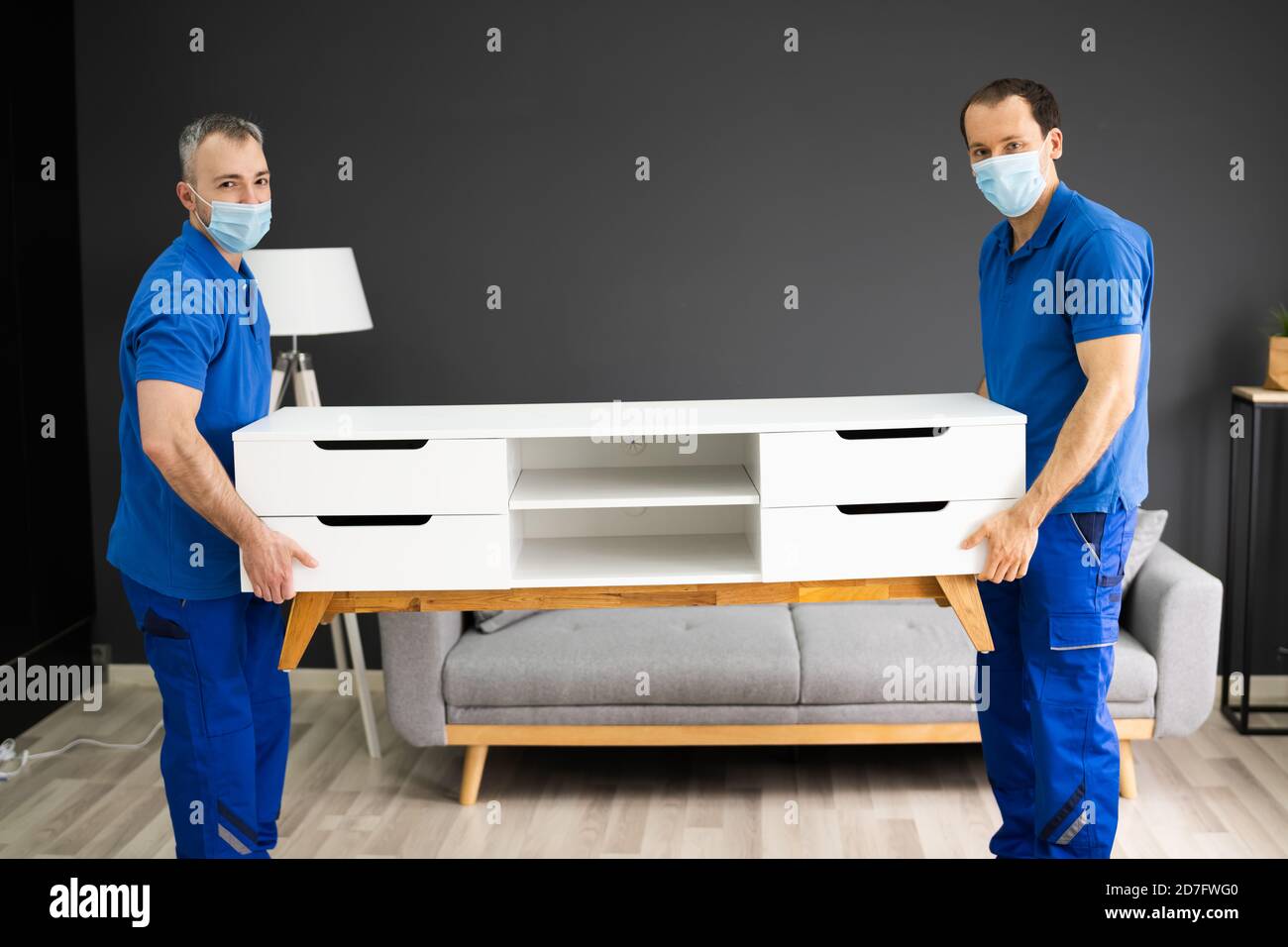 Professional Movers Moving TV Console Furniture In Face Mask Stock ...