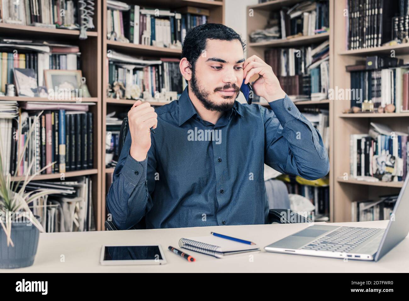 Young entrepreneur working from home, talking on his cell phone Stock ...