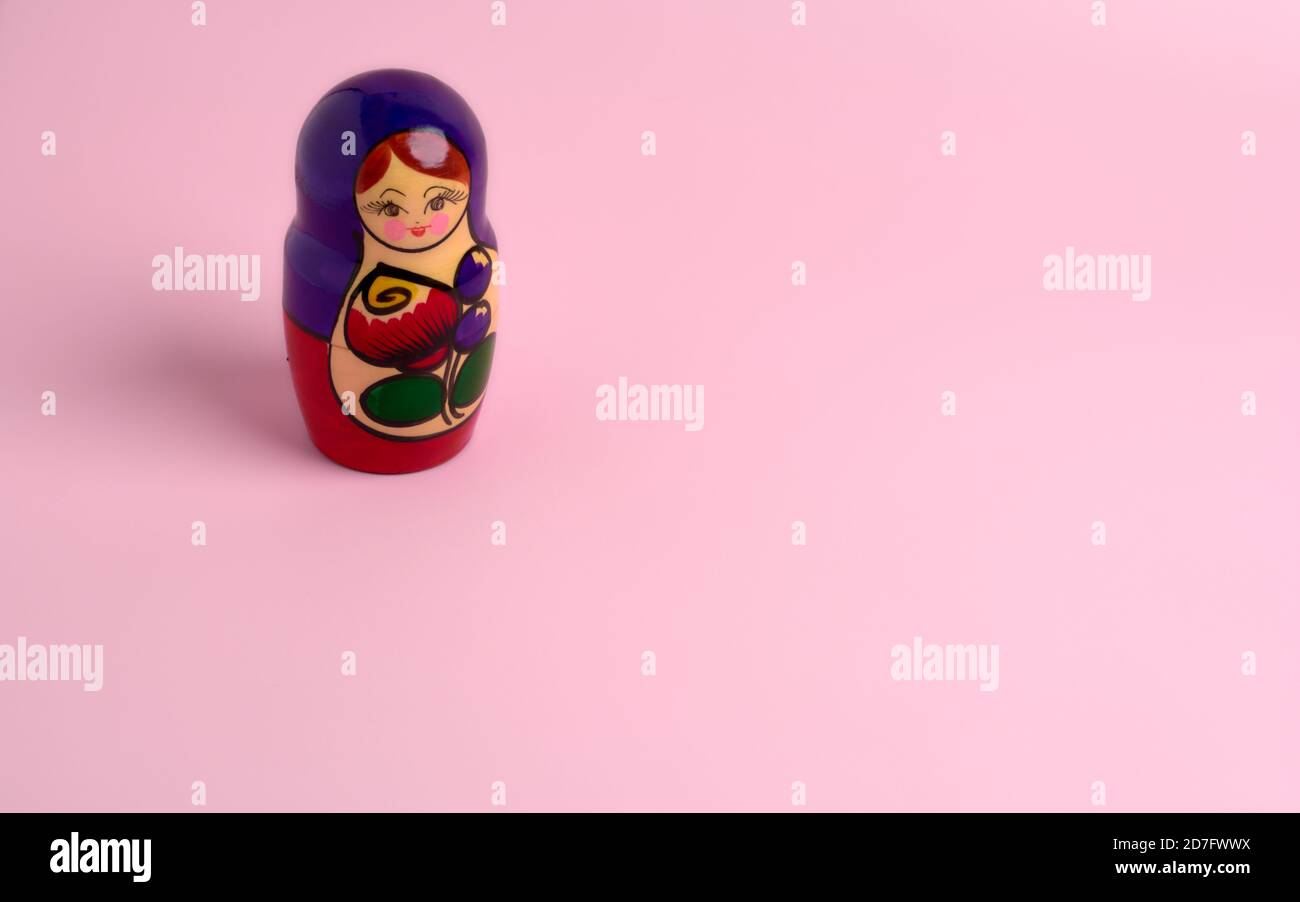 detail of matryoshka dolls of various colors on a smooth pink ...