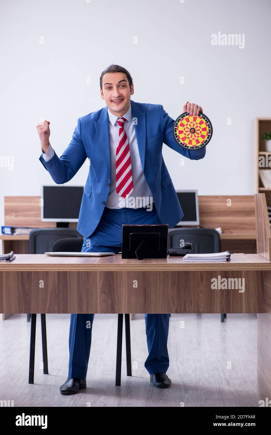 Young employee playing darts in the office Stock Photo - Alamy