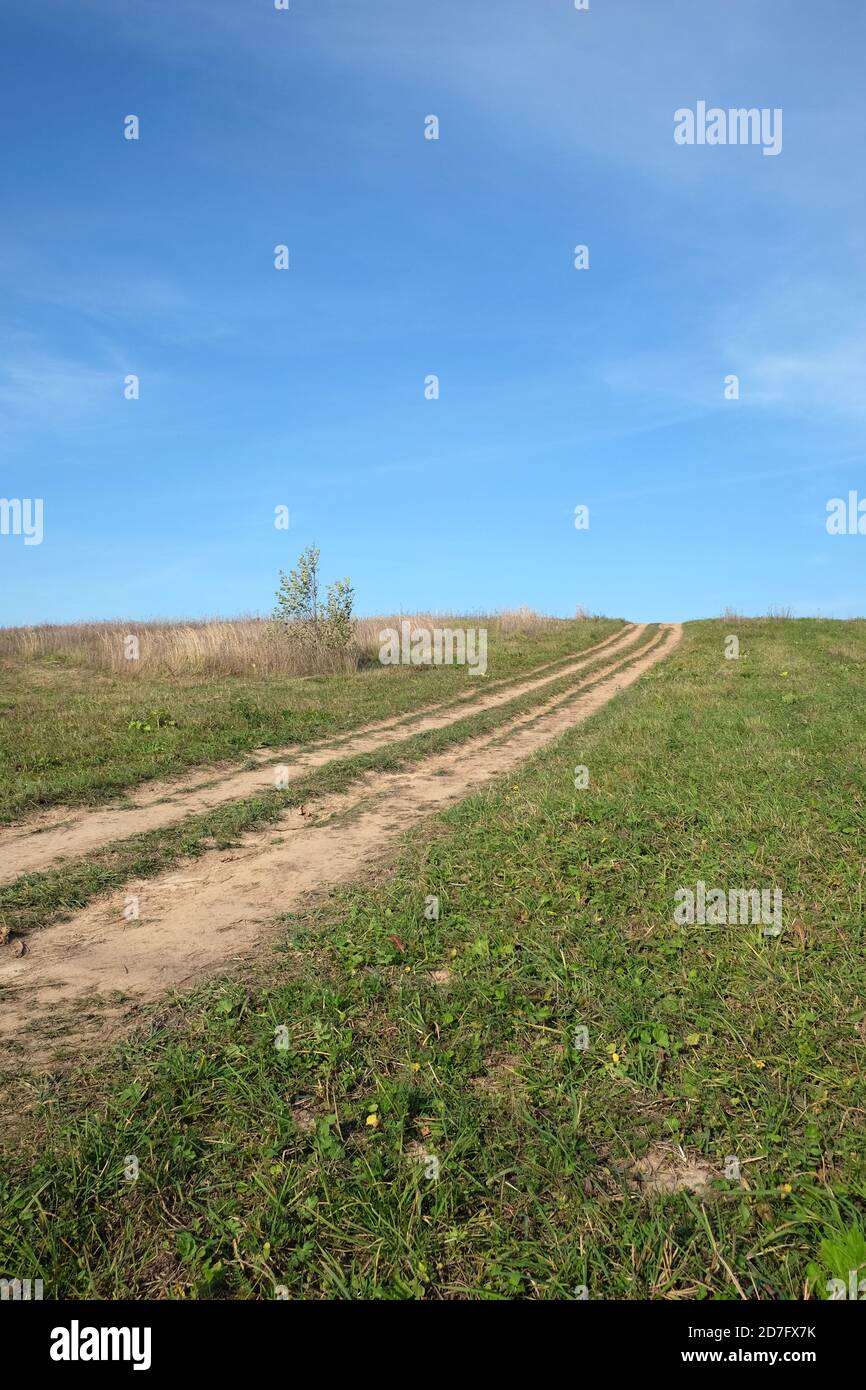 Beautiful rustic landscape with front view of ground road runs ahead ...