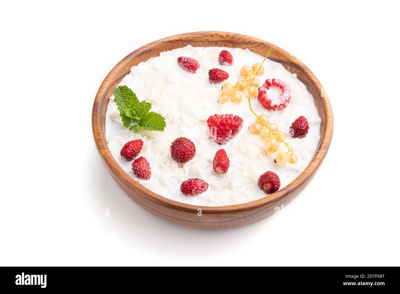 Rice flakes porridge with milk and strawberry in wooden bowl isolated ...