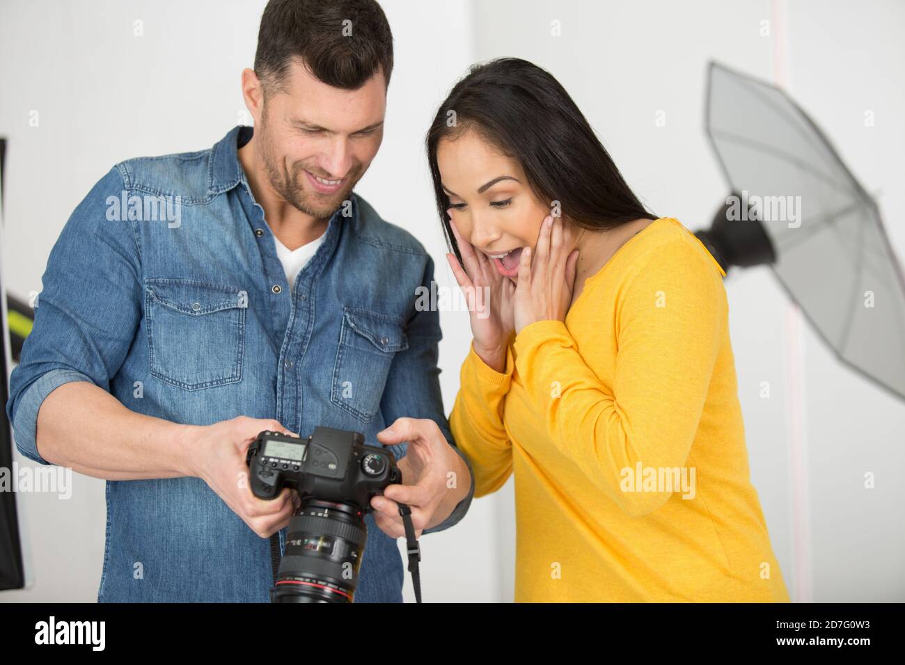 professional photographer showing pictures to model in studio Stock ...
