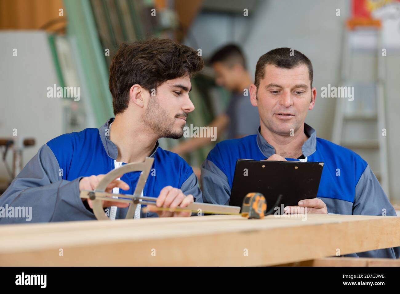 workmen using precision measuring tool in factory Stock Photo - Alamy