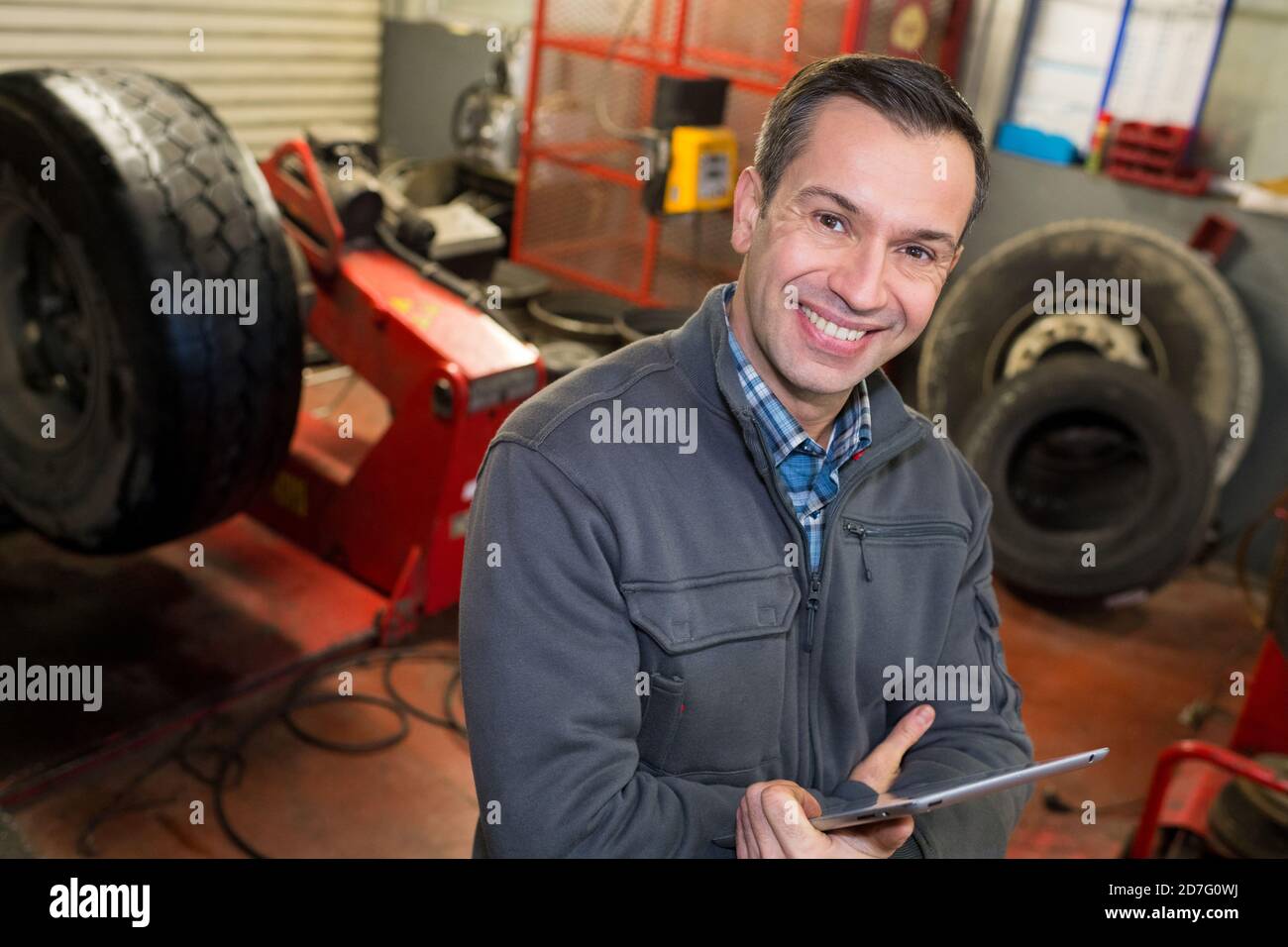 portrait of vulcanizing shop worker smiling Stock Photo - Alamy