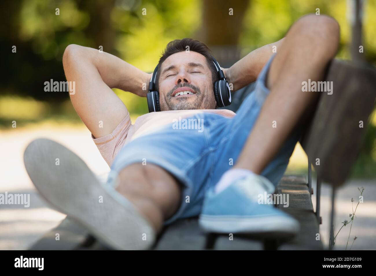 handsome man lying on bench Stock Photo - Alamy