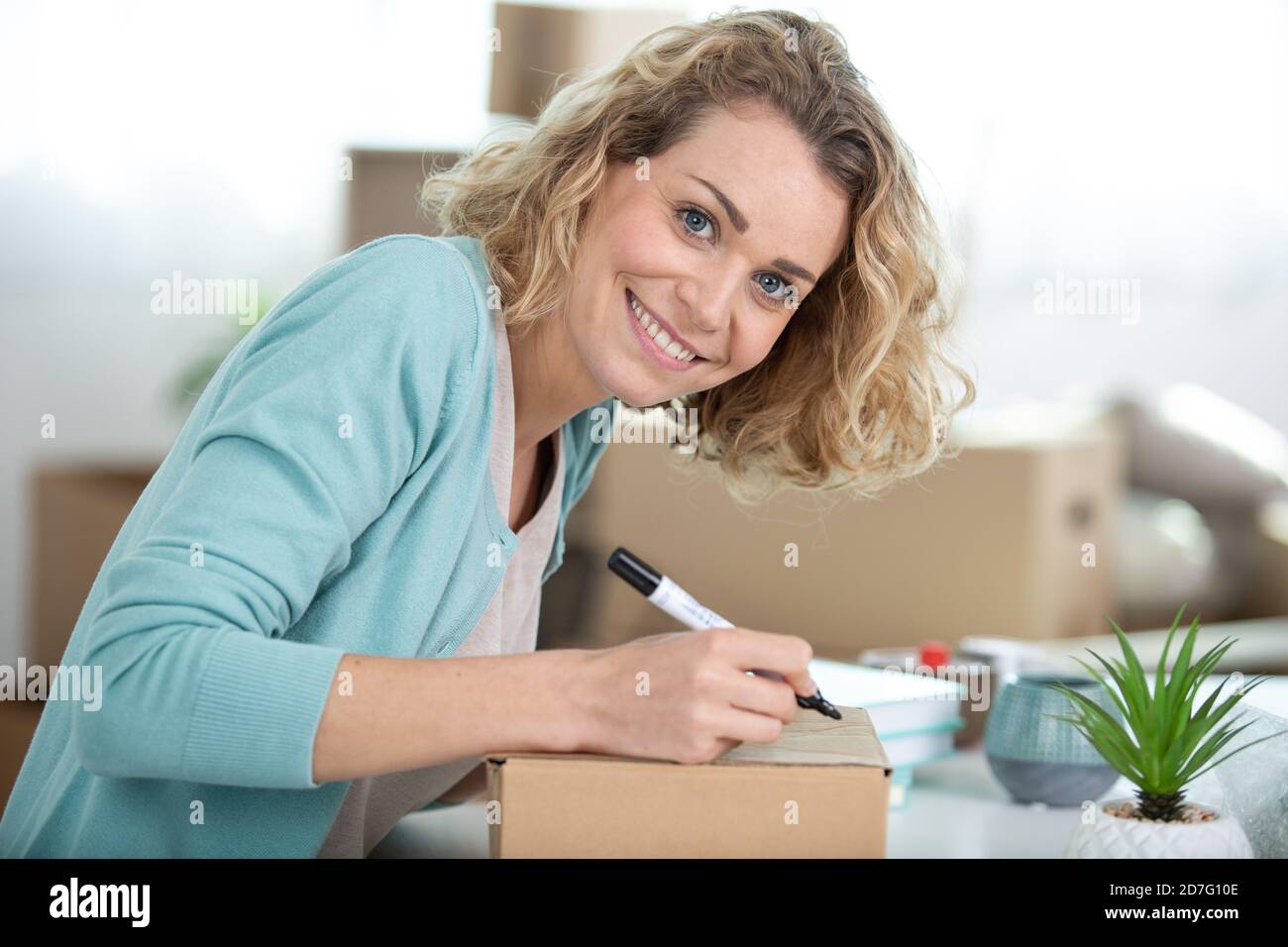 attractive woman signing on delivery paper Stock Photo - Alamy