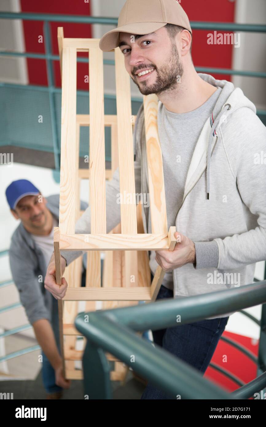 two men carrying new furniture Stock Photo - Alamy