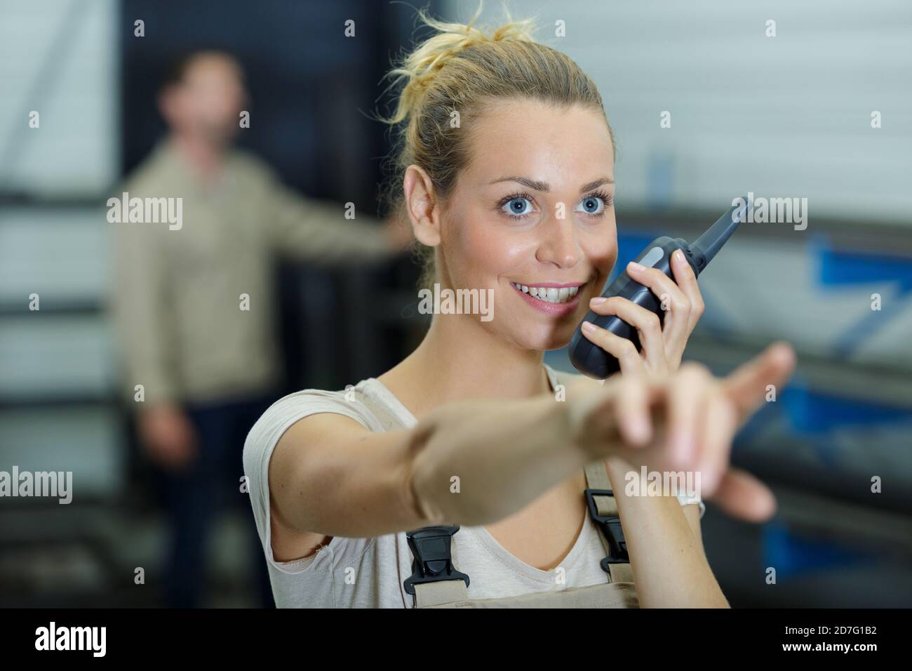 woman holding a radio while pointing at something Stock Photo - Alamy
