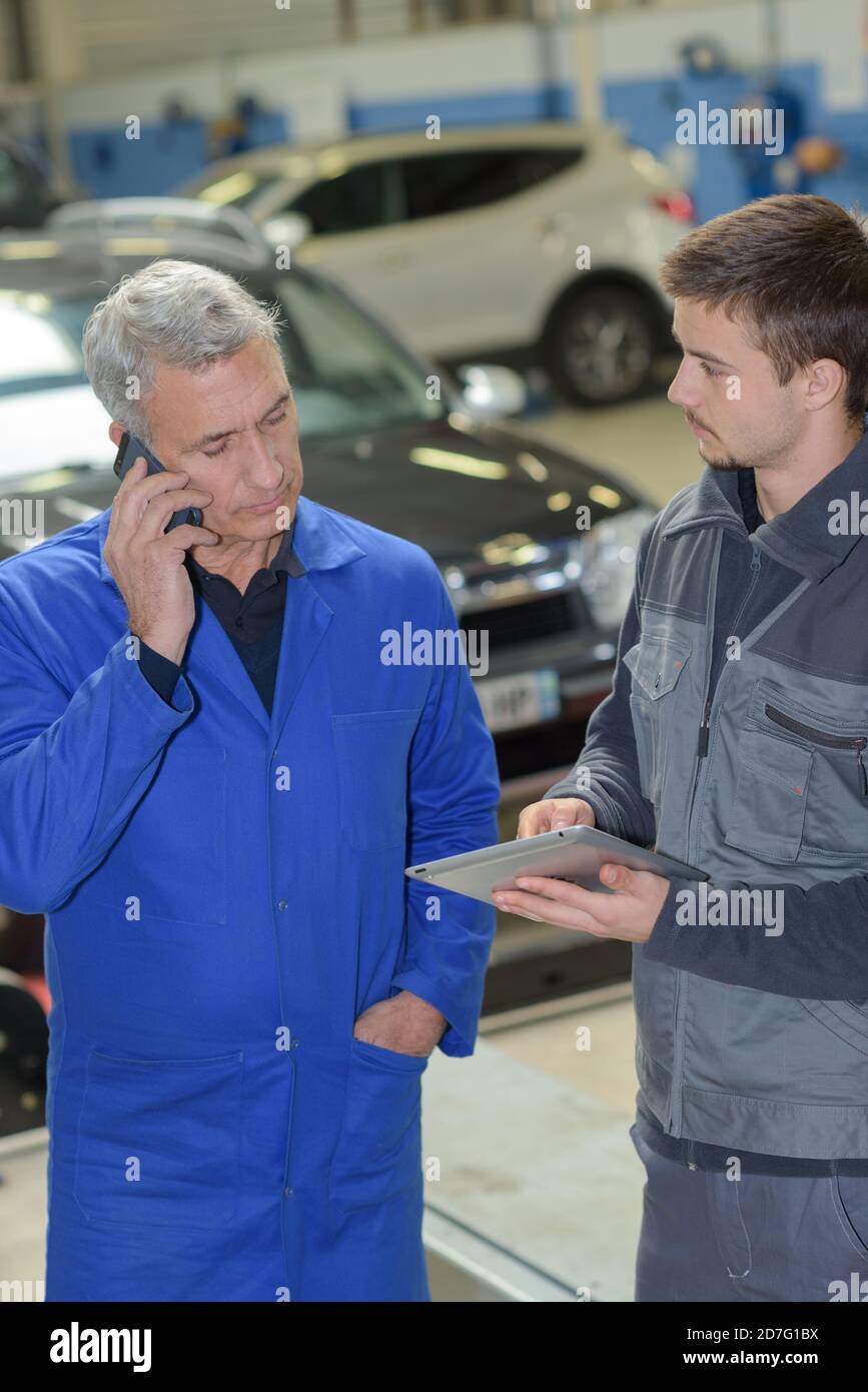 teenager in professional training with garage owner Stock Photo - Alamy