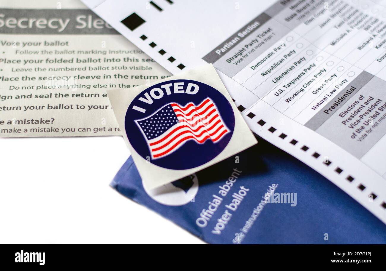 Absent voter forms and sticker against a white background with room for ...