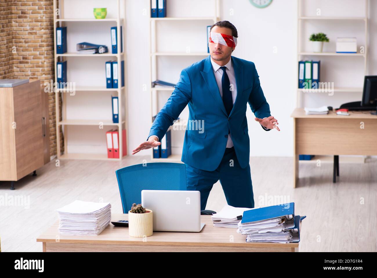 Blindfolded employee working in the office Stock Photo - Alamy