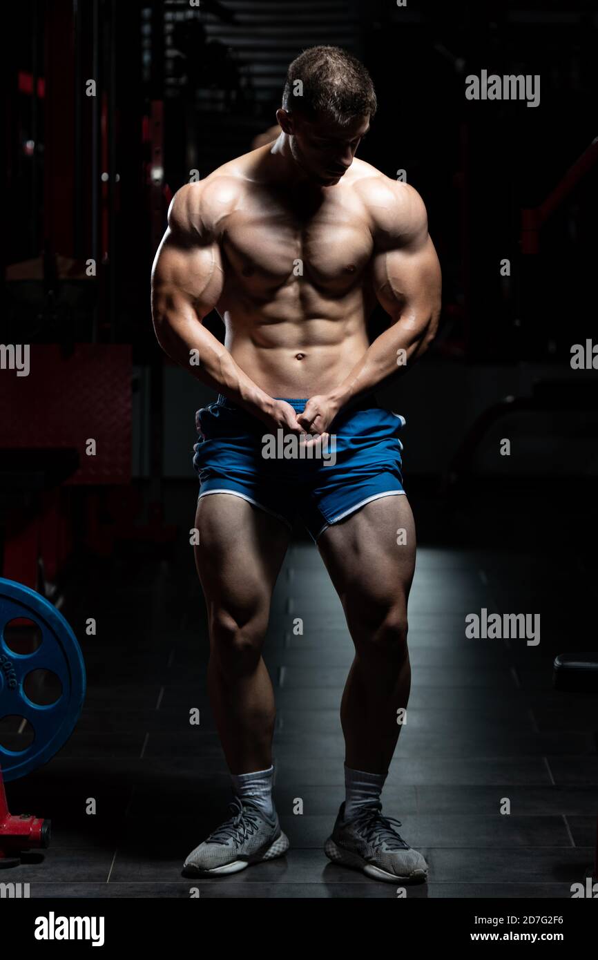 Handsome Man Standing Strong In The Gym And Flexing Muscles - Muscular ...