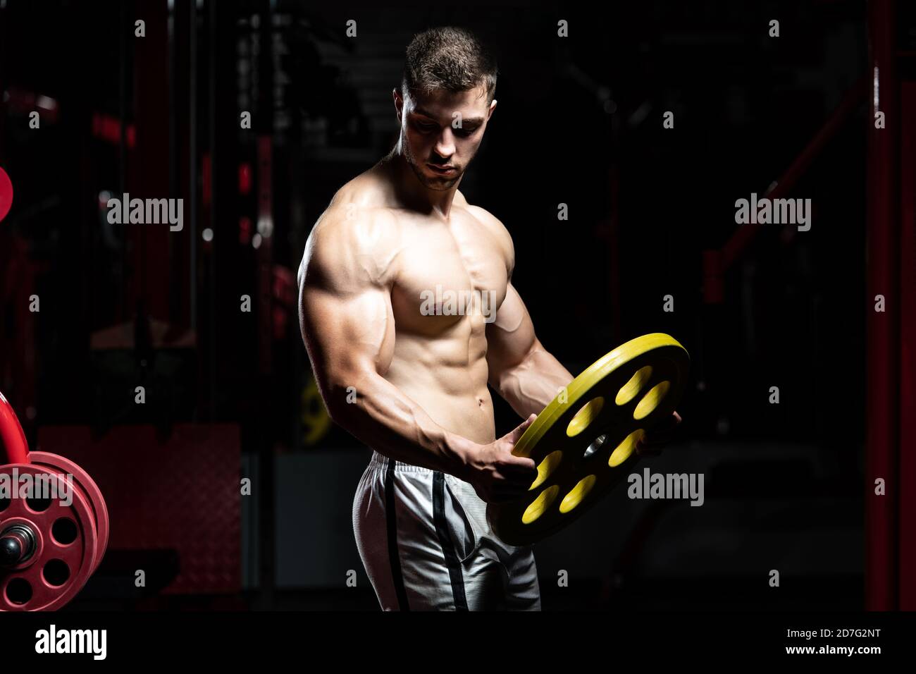 Portrait Of A Physically Young Man Holding Weights In Hand Stock Photo ...