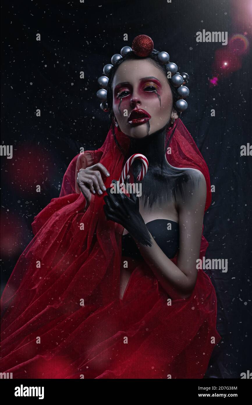 Surreal photo of a witch girl with black eyes and candy in her hands ...