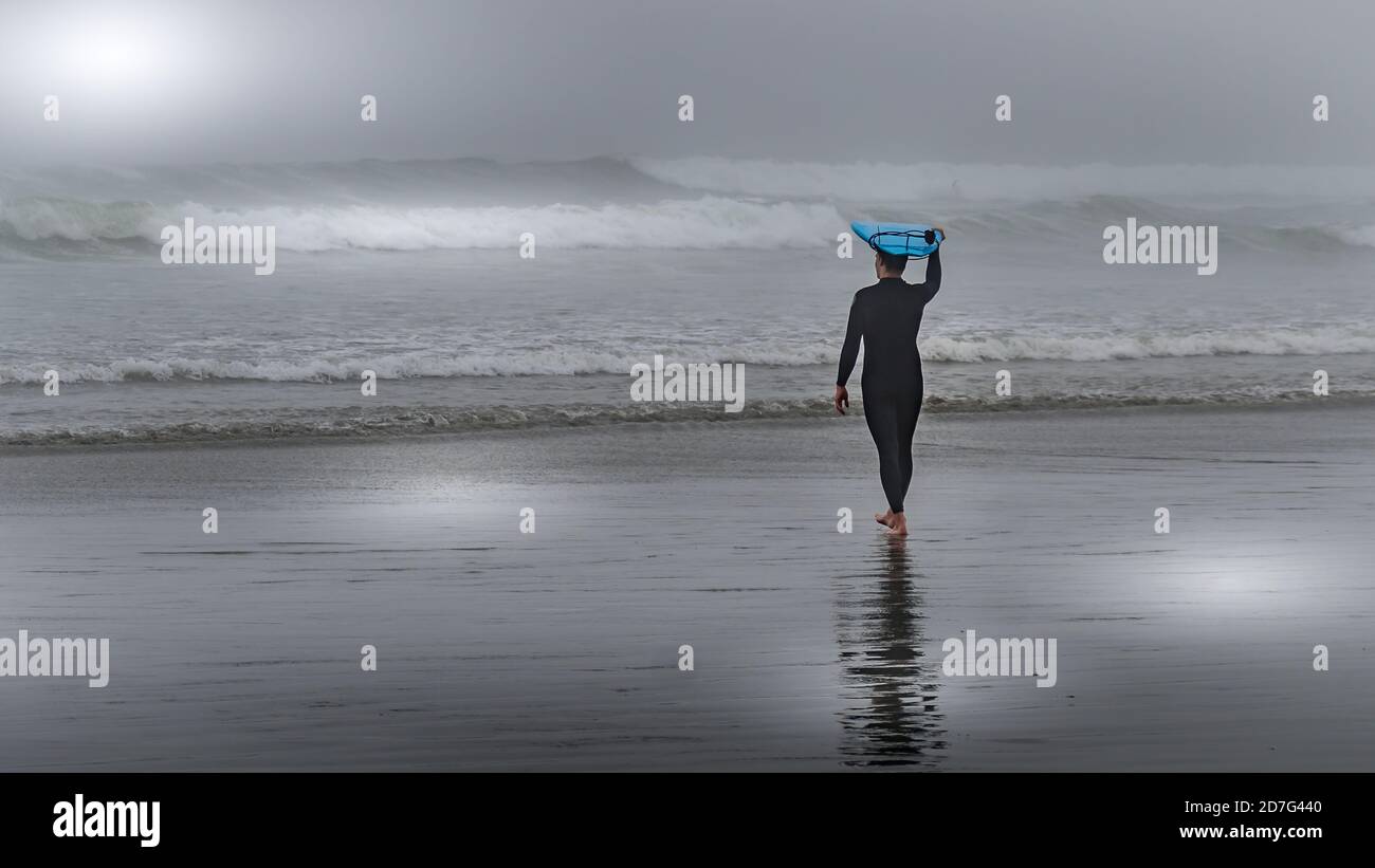 Surfer heading into the Waves in the Dense Fog to surf in Cox Bay at ...