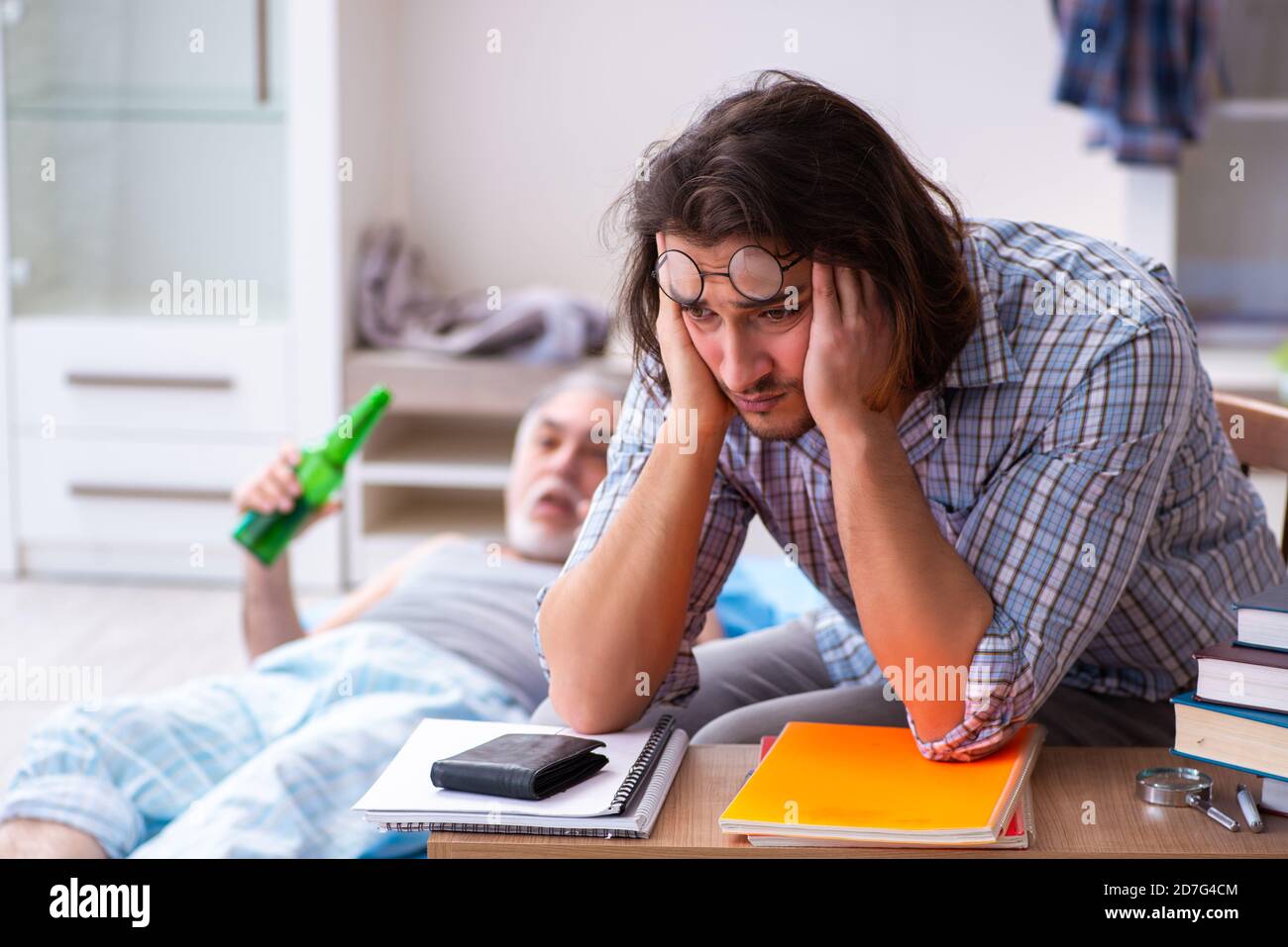Young son student and dad alcoholic at home Stock Photo - Alamy