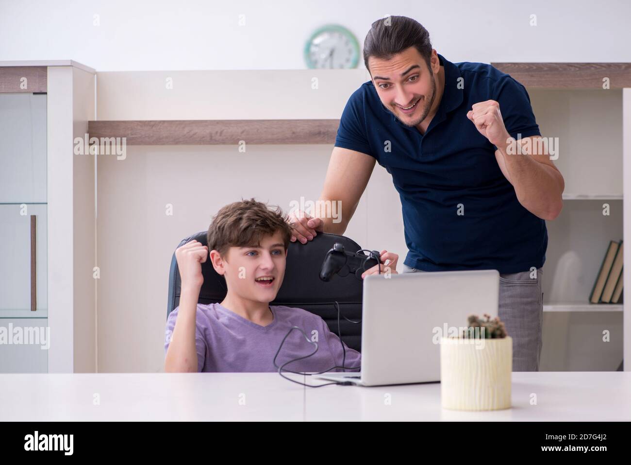 Father and schoolboy playing computer games at home Stock Photo - Alamy