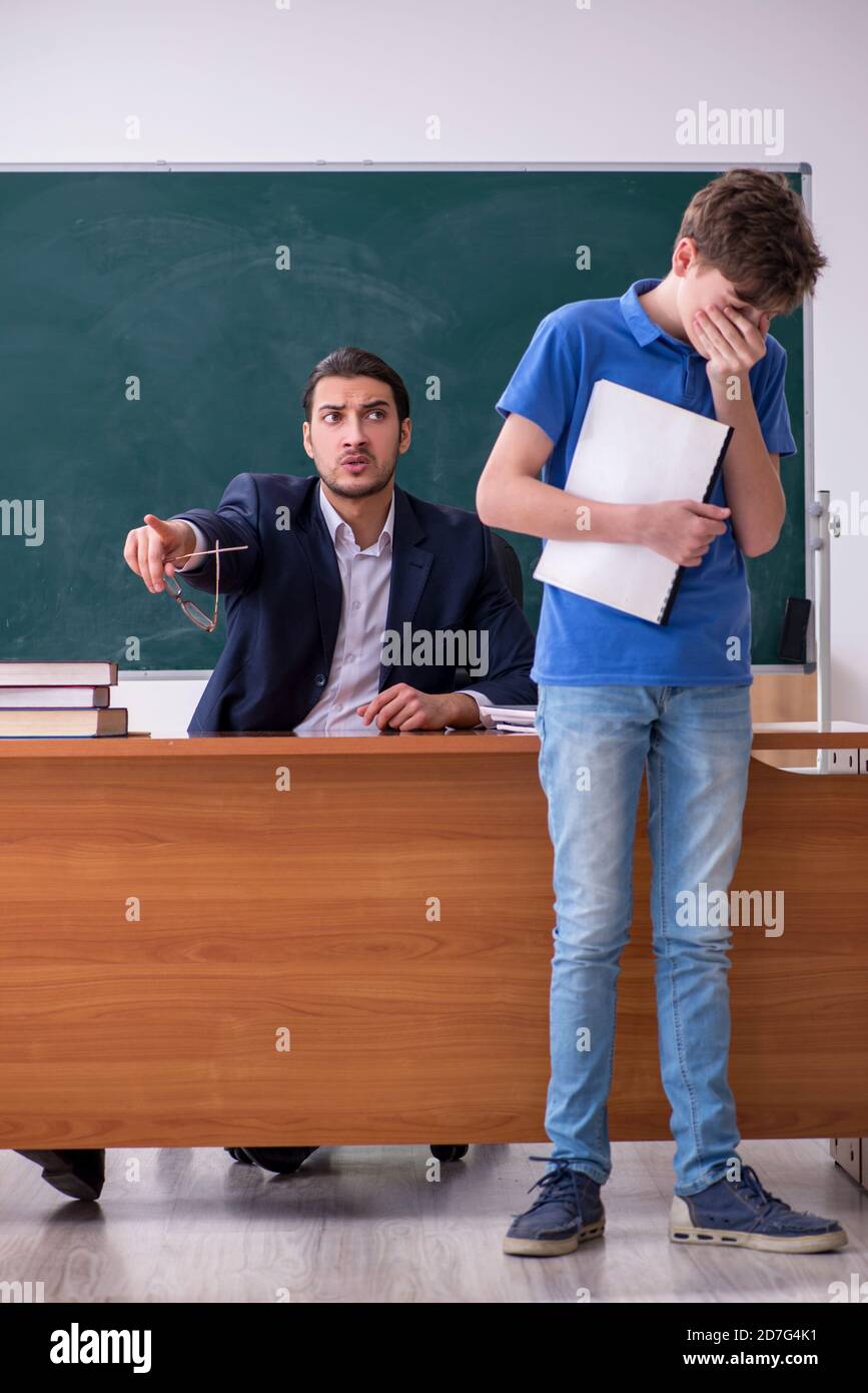 Male teacher and schoolboy in the classroom Stock Photo - Alamy