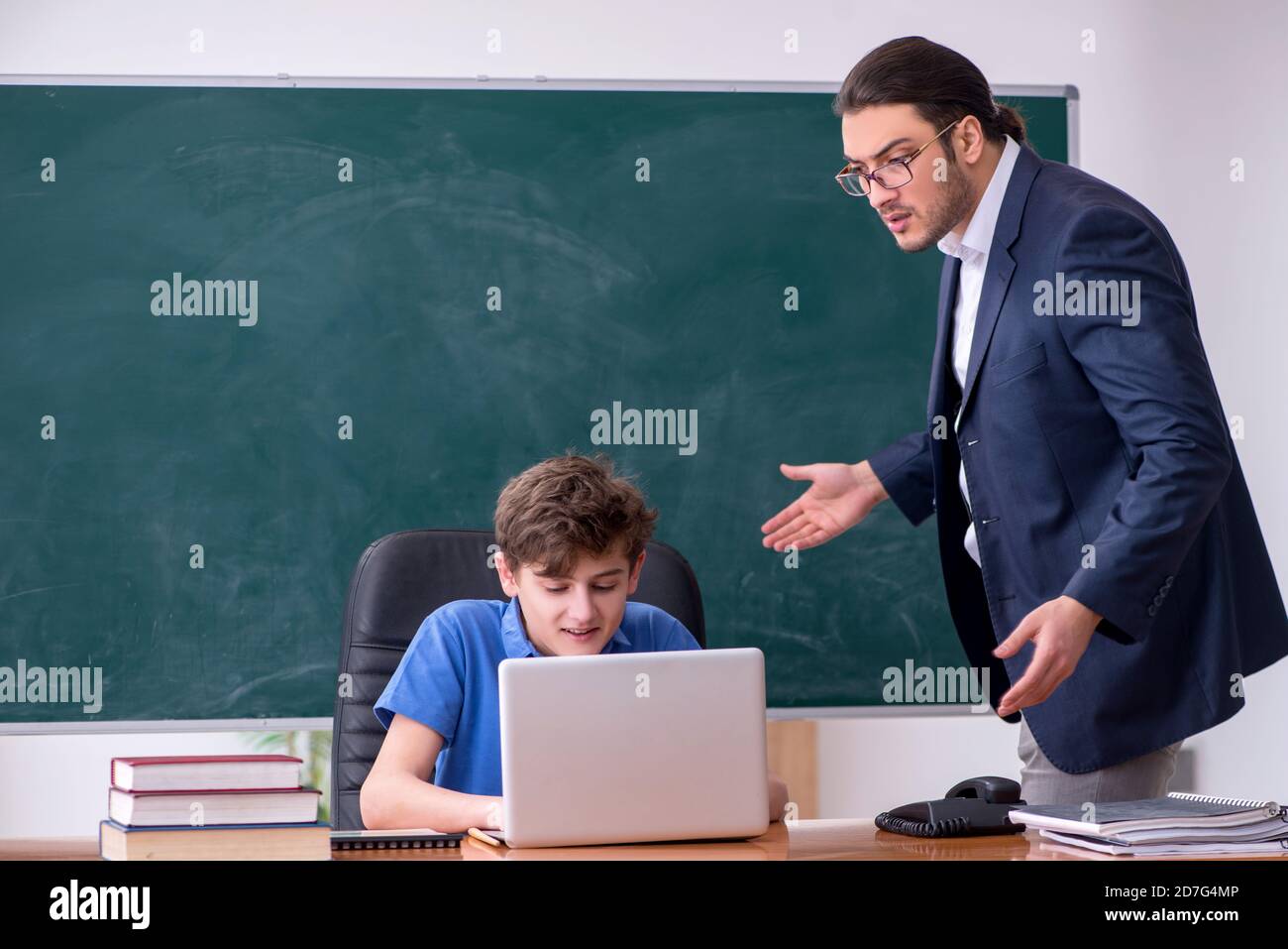 Male teacher and schoolboy in the classroom Stock Photo - Alamy