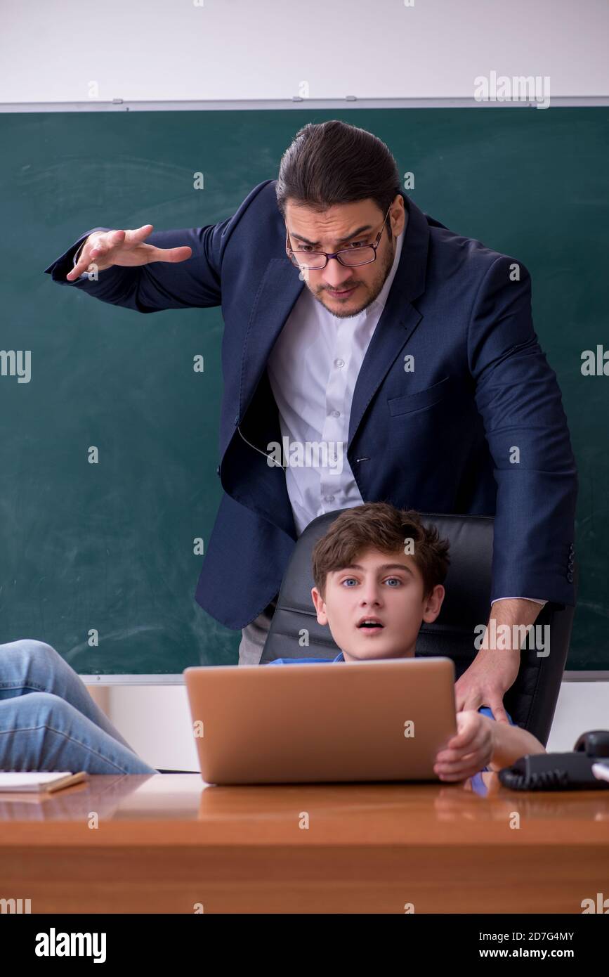 Male teacher and schoolboy in the classroom Stock Photo - Alamy