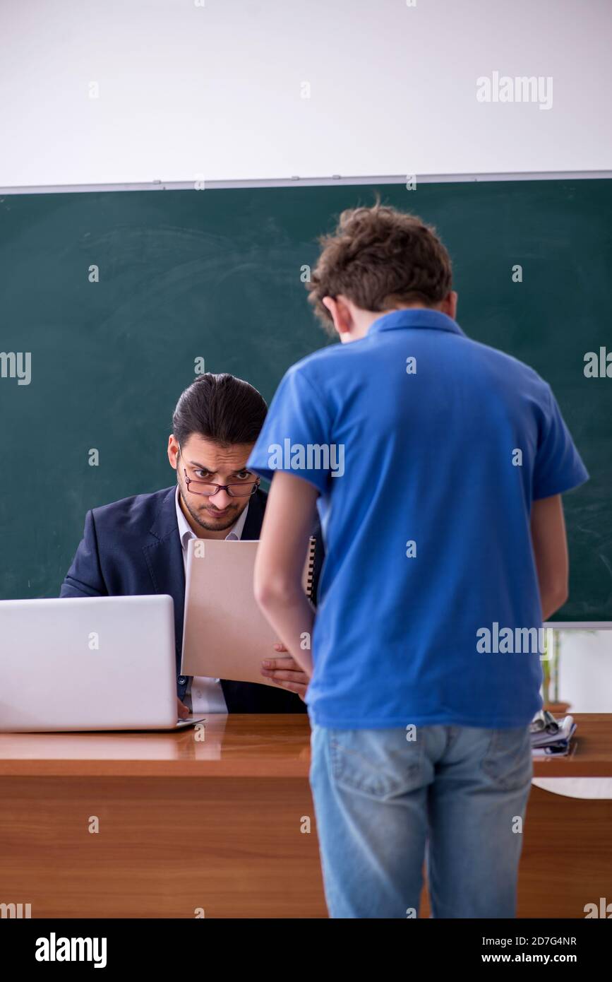 Male teacher and schoolboy in the classroom Stock Photo - Alamy
