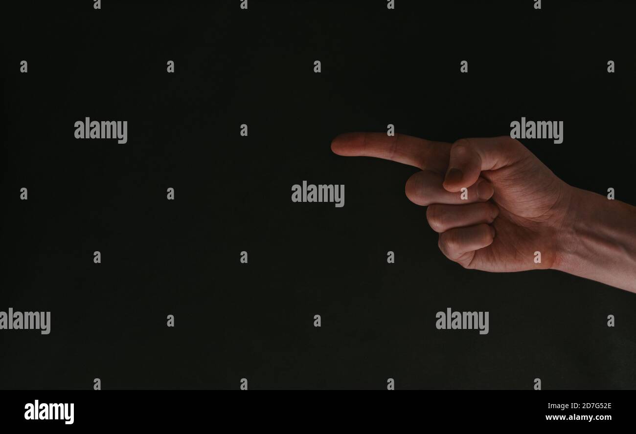 Right-hand index finger directing showing the left side on a black ...