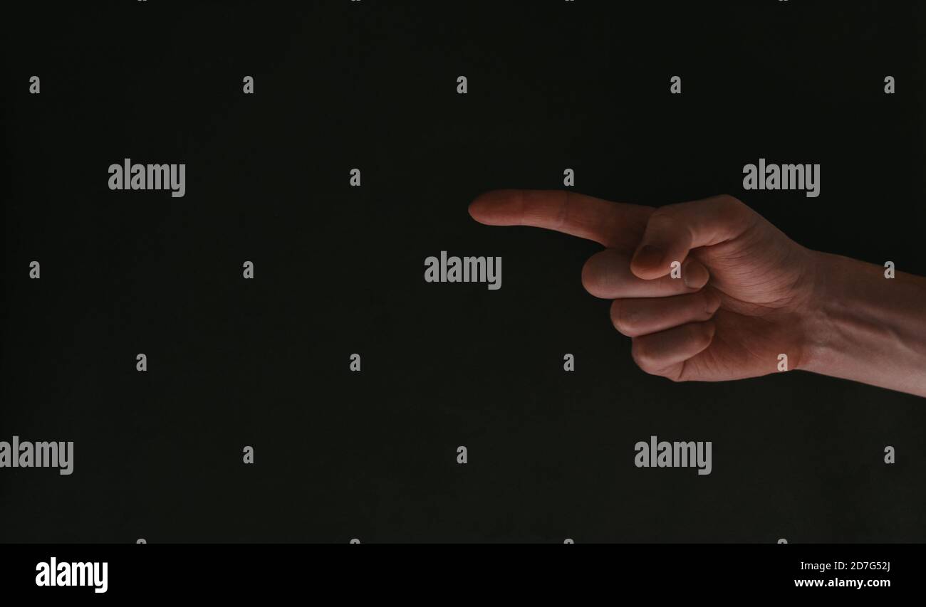Right-hand index finger showing the left side on a black background ...