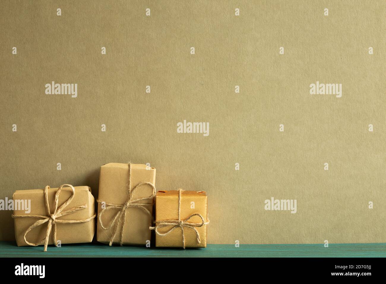 Gift boxes wrapped in kraft paper on wooden table with khaki green ...