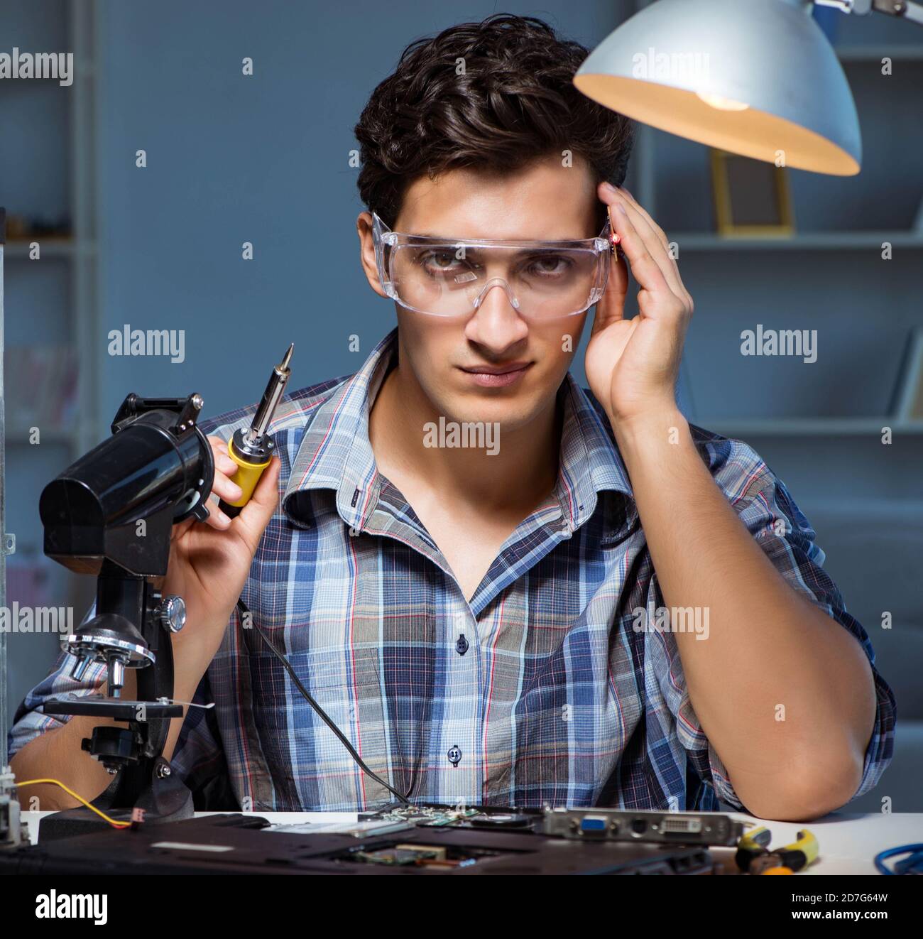 The repairman trying to repair laptop with miscroscope Stock Photo - Alamy