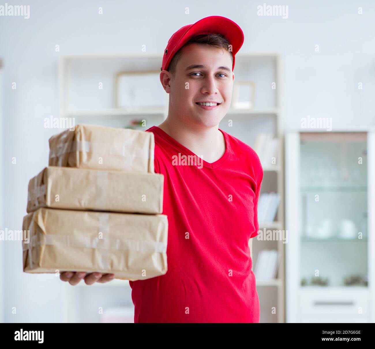The post man delivering a parcel package Stock Photo - Alamy