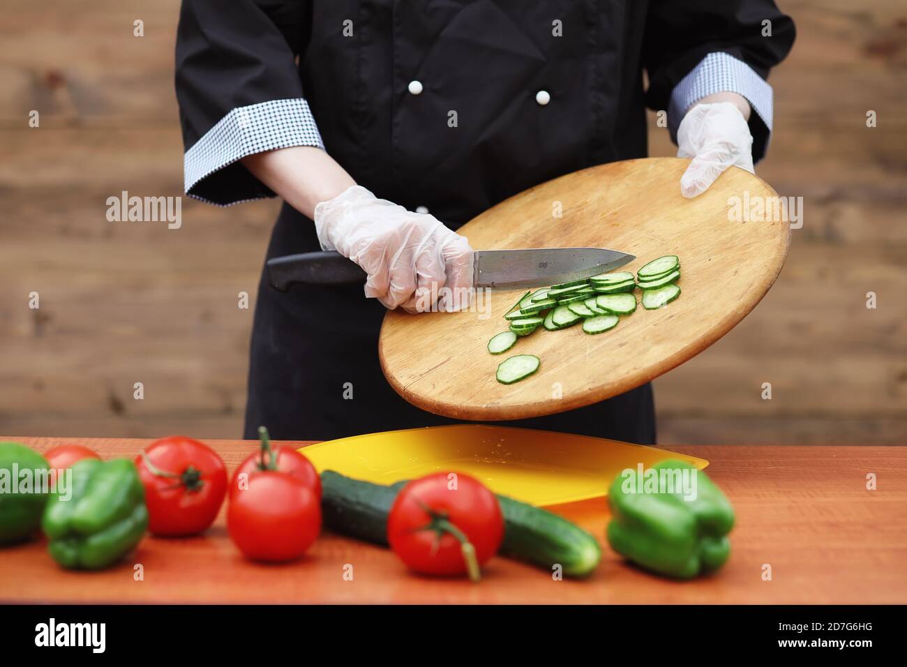 The cook cuts fresh farm vegetables for dinner on the table Stock Photo ...