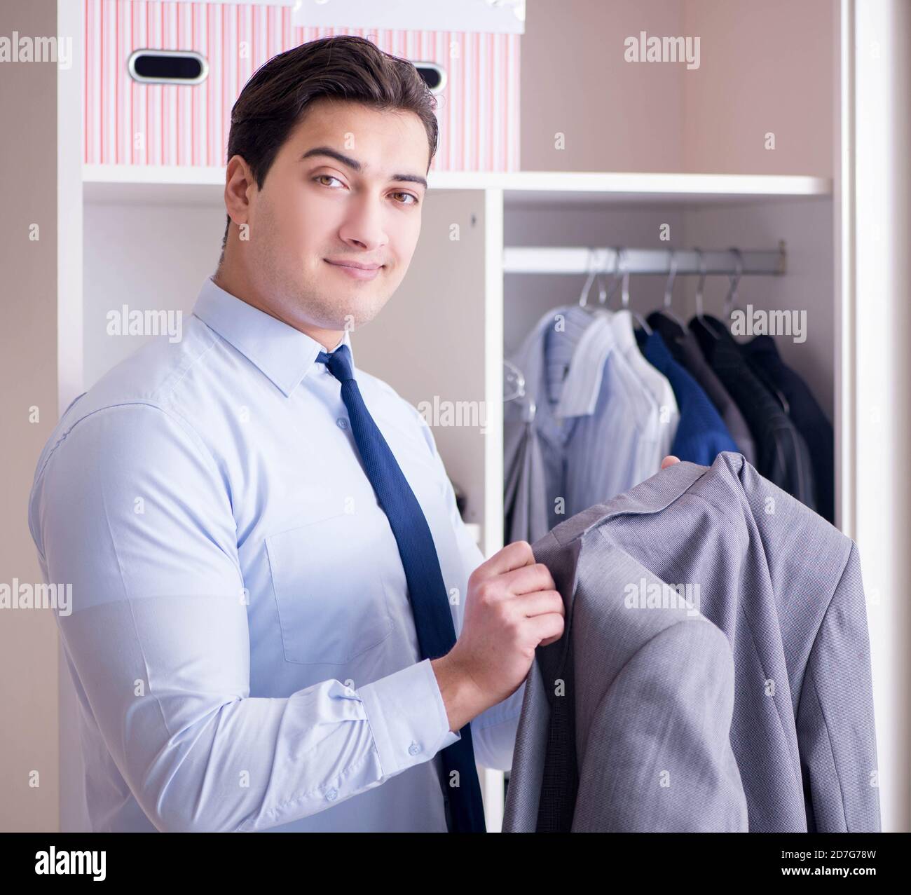 The young man businessman getting dressed for work Stock Photo - Alamy