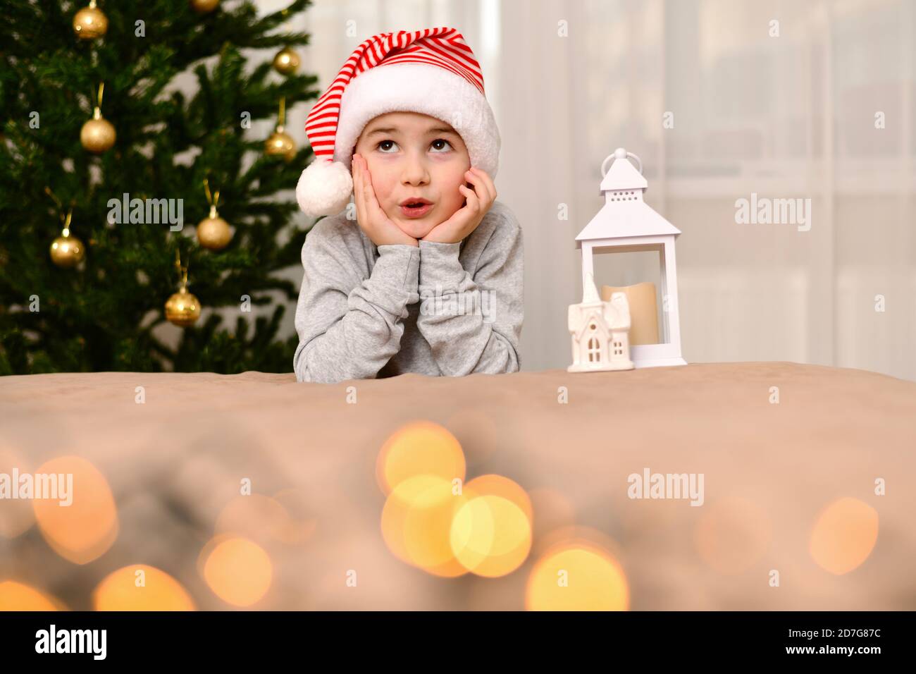 A child in a carnival striped cap rolled his eyes in surprise and ...