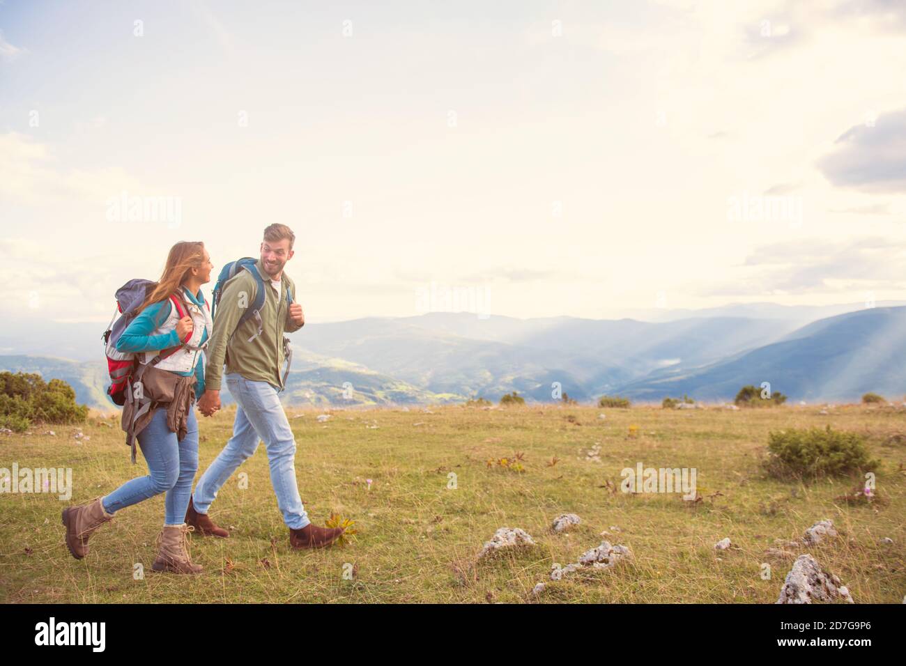 Young couple enjoying their in the mountains on backpacking trip. Side ...