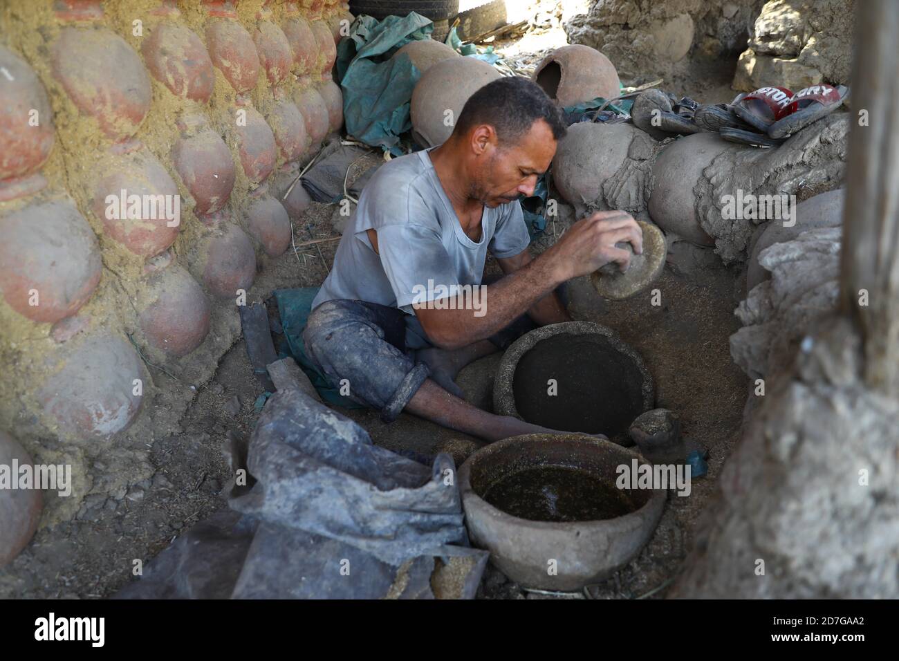 Fayoum, Egypt. 5th Oct, 2020. A potter hammers wet clay which is mixed ...