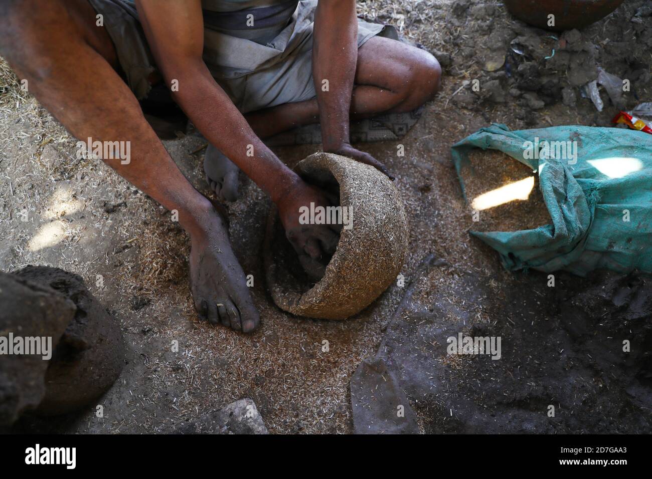 Fayoum, Egypt. 5th Oct, 2020. A potter hammers wet clay which is mixed ...