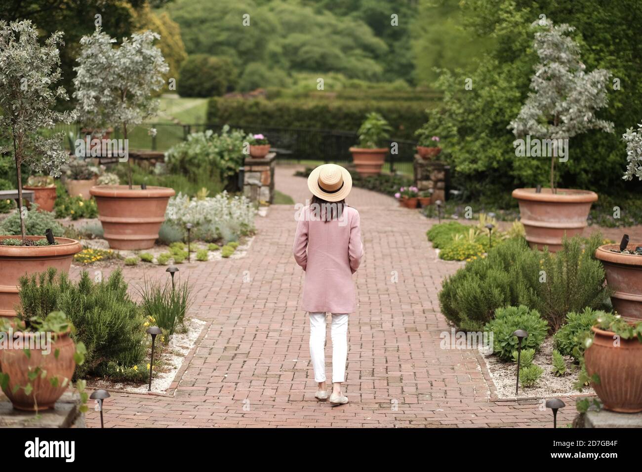 Woman walking in a garden Stock Photo - Alamy