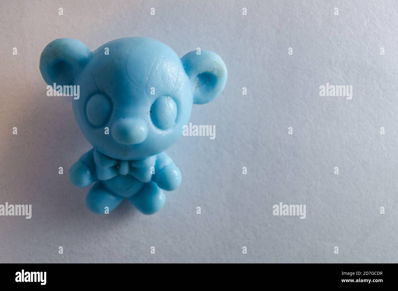 Flat lay of a small blue plastic bear toy against a white background ...