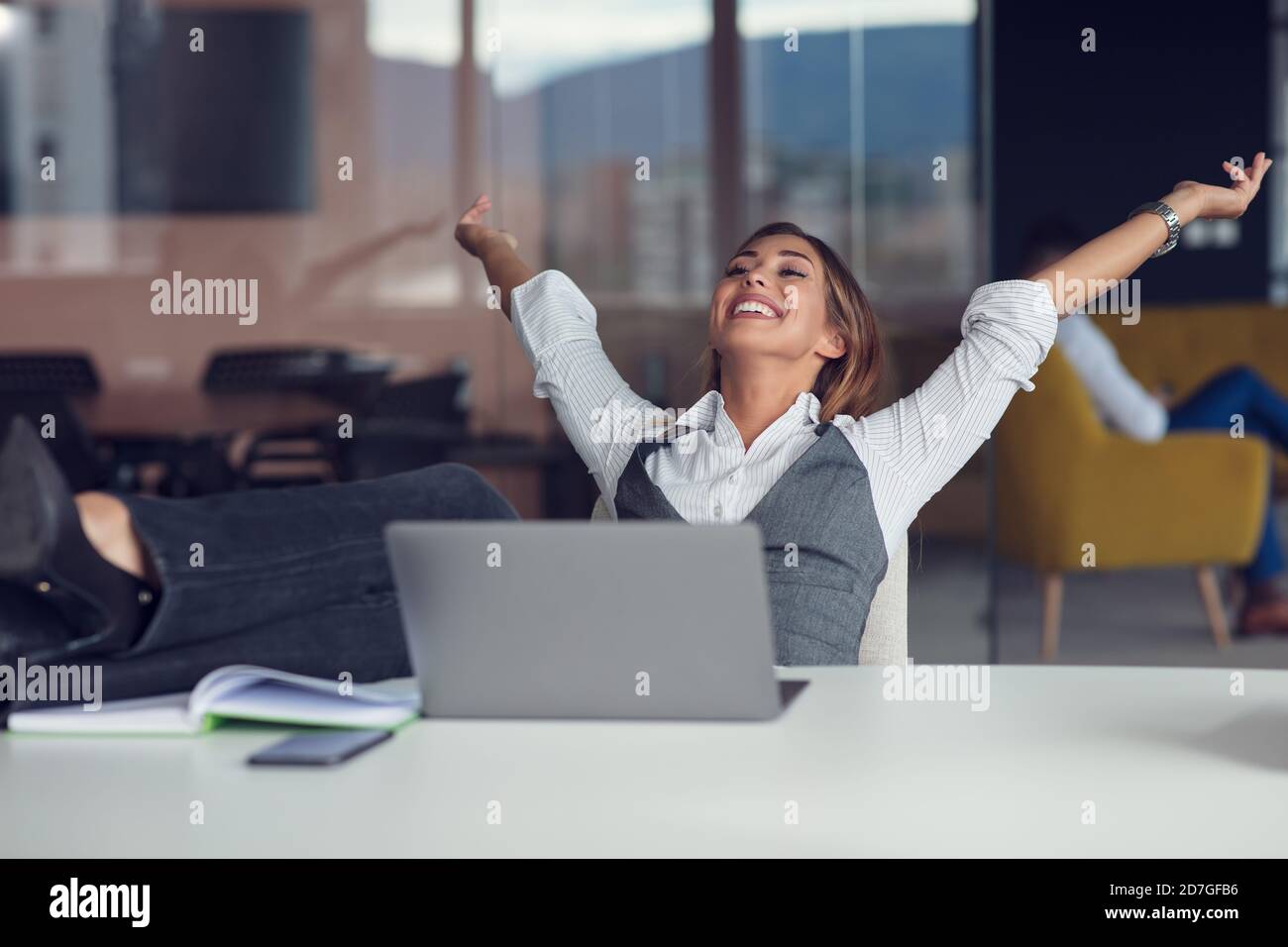 Time to relax. Cheerful young beautiful woman keeping hands behind head ...