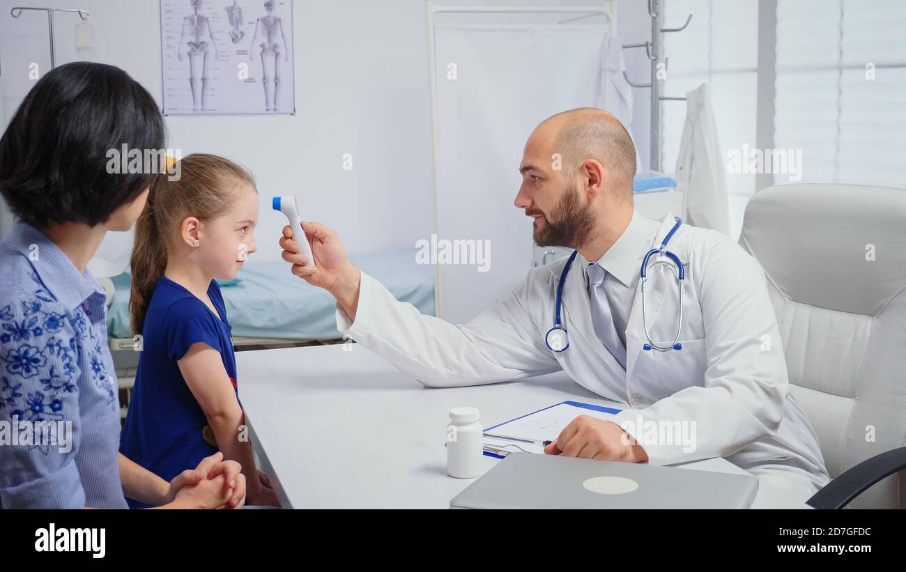 Doctor checking evolution of the fever while nurse taking notes ...