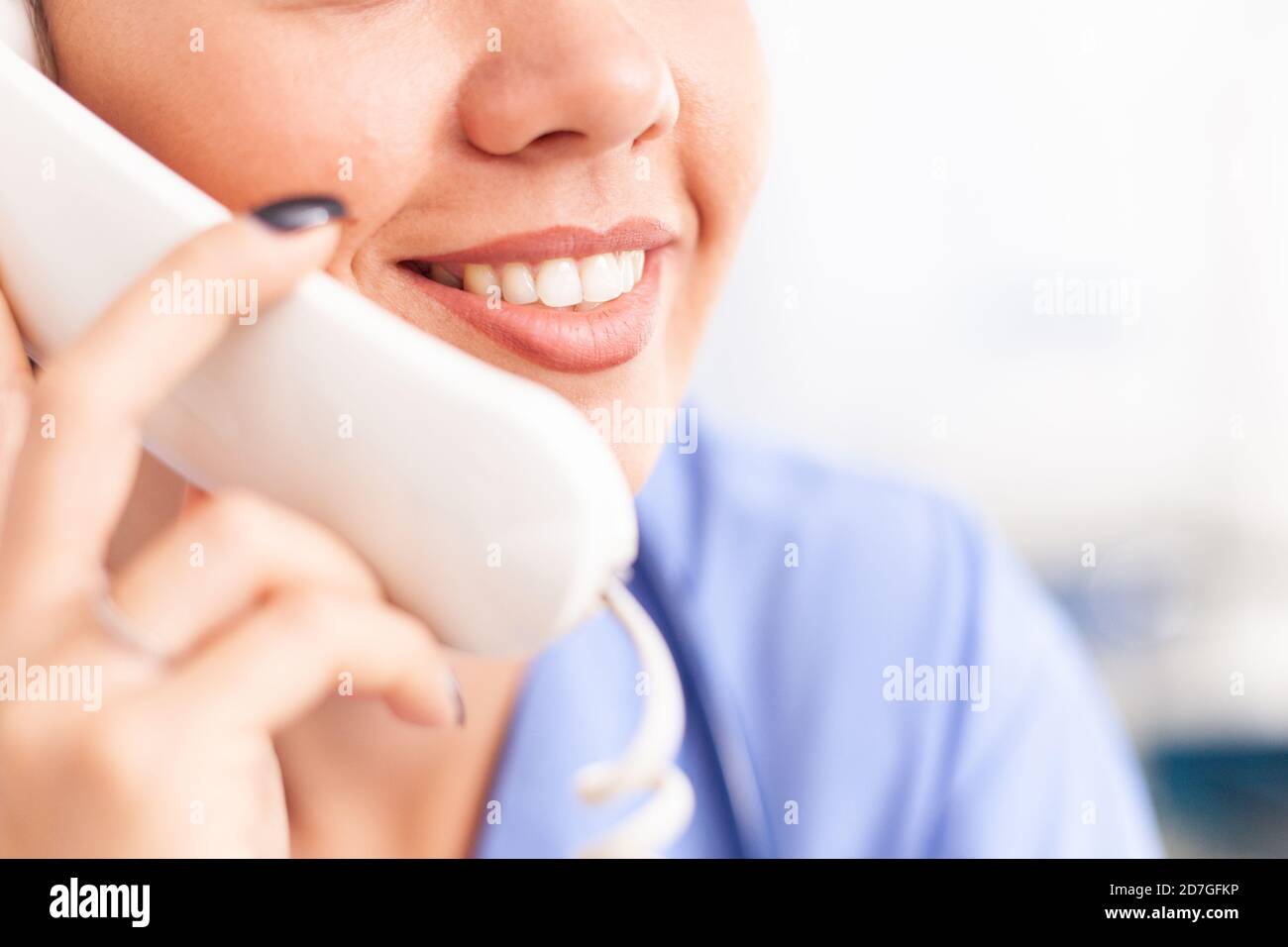Woman nurse answering telephone in hospital reception. Female nurse ...