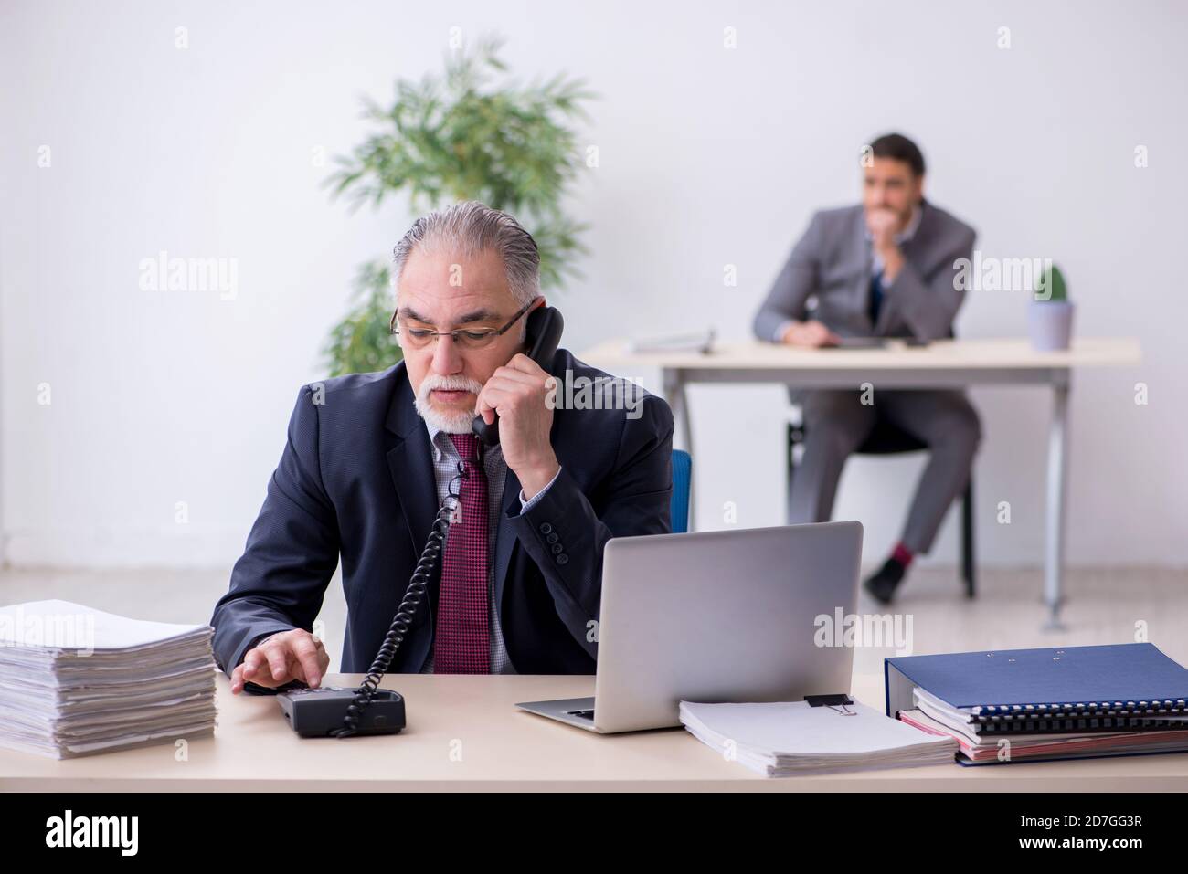 Old boss and his assistant working in the office Stock Photo - Alamy