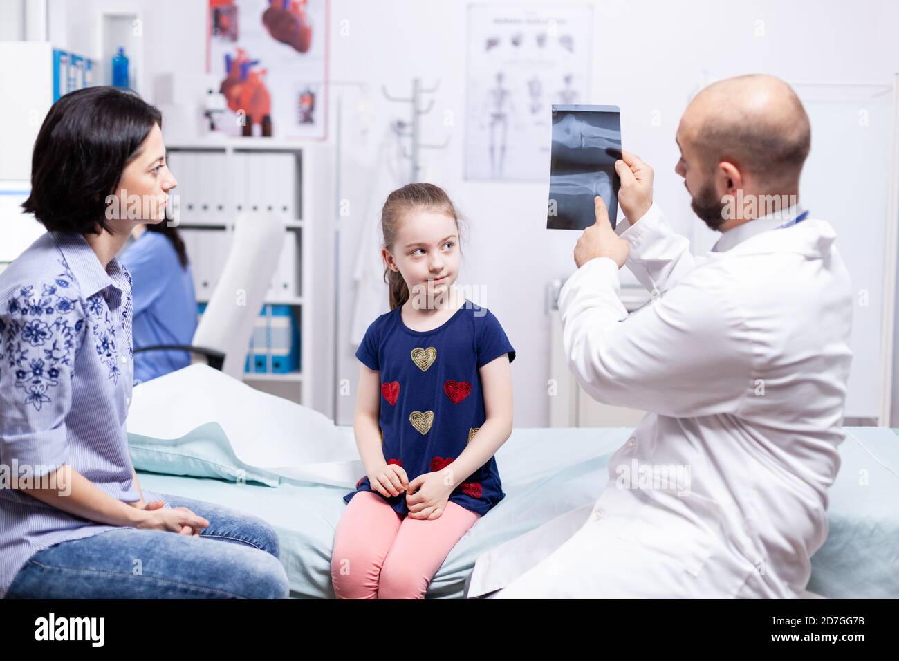 Doctor with mother and child looking at radiography in hospital office ...