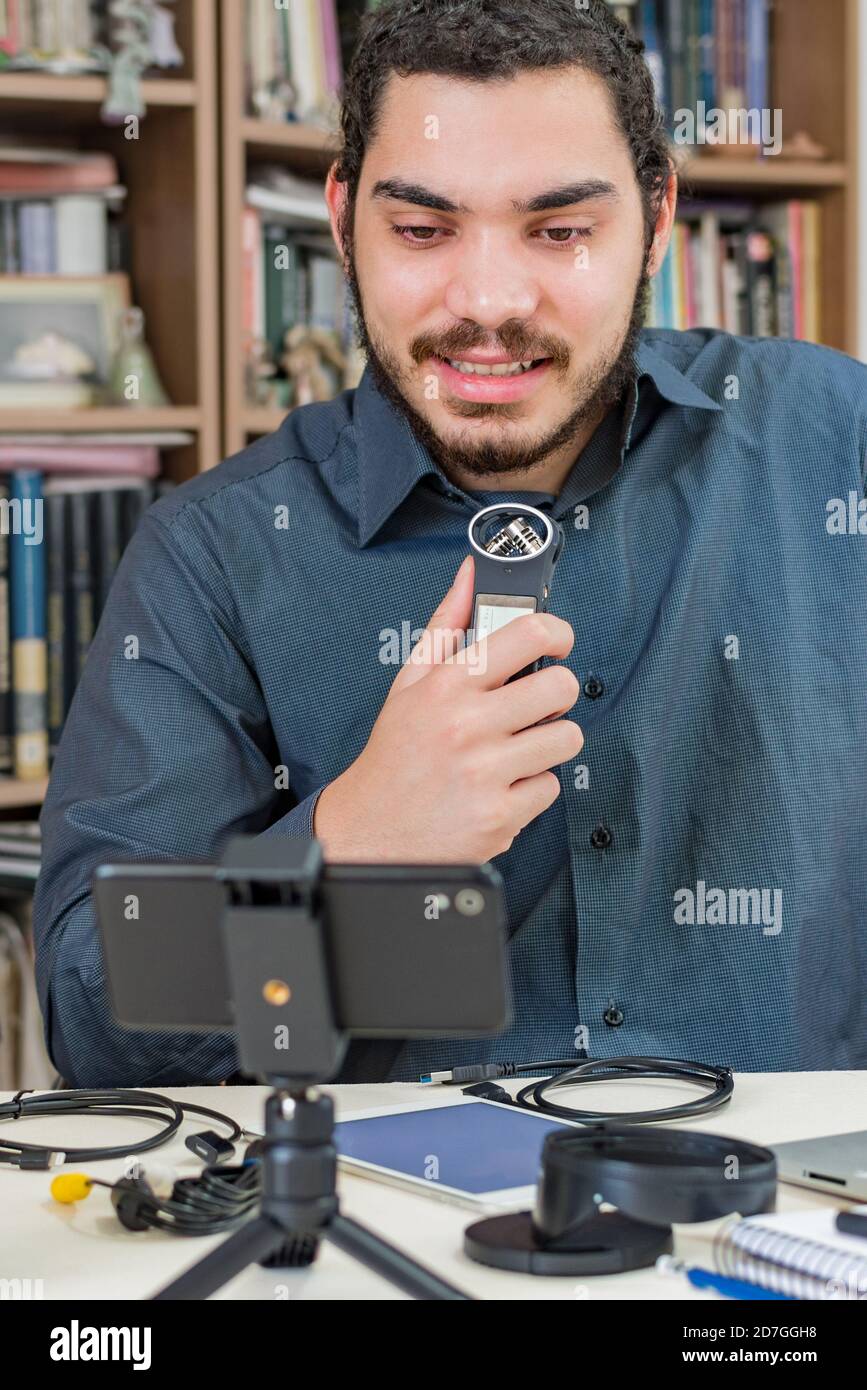Young Caucasian blogger man recording a new video with a mobile phone ...