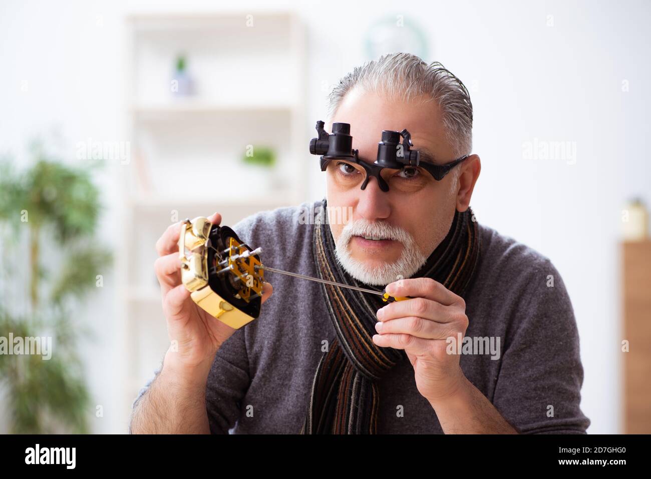 Old watchmaker working in the workshop Stock Photo - Alamy
