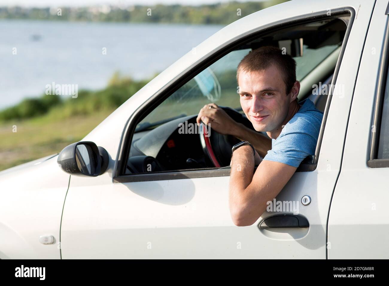 A young man looks out of the window of his car Stock Photo - Alamy