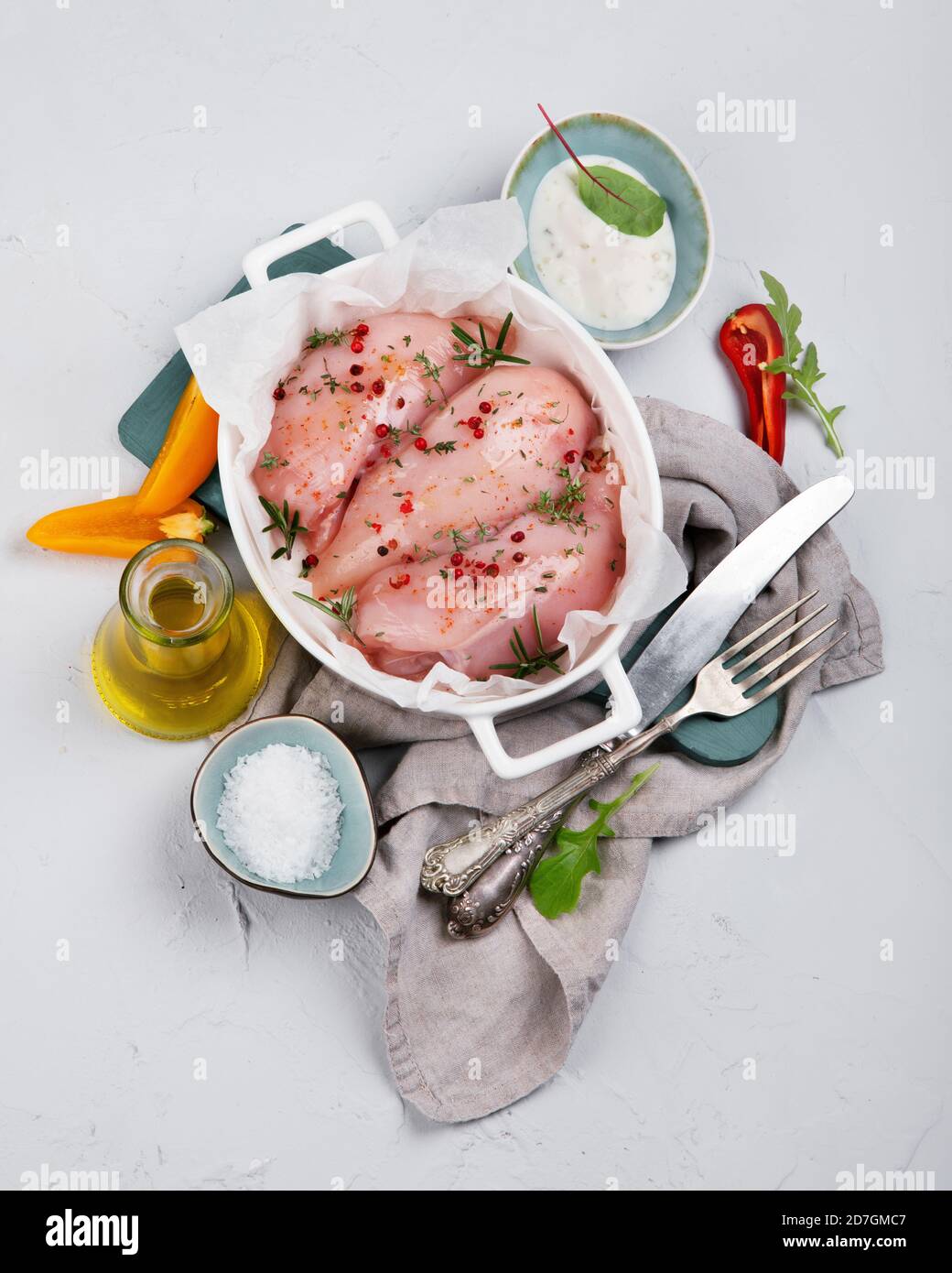 Fresh raw chicken fillet with spices, herbs and vegetables. Preparing ...