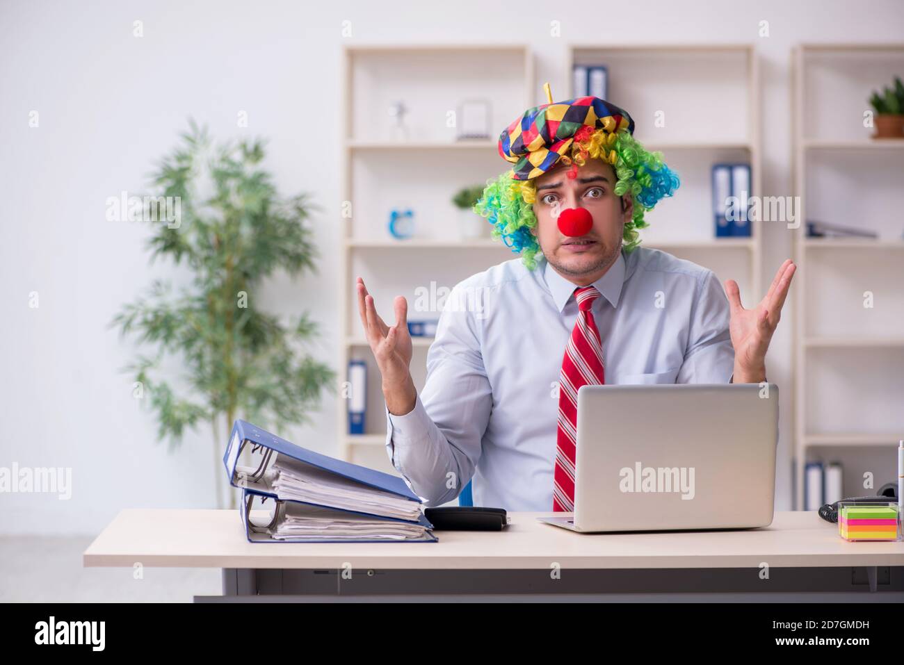 Funny employee clown working in the office room Stock Photo - Alamy